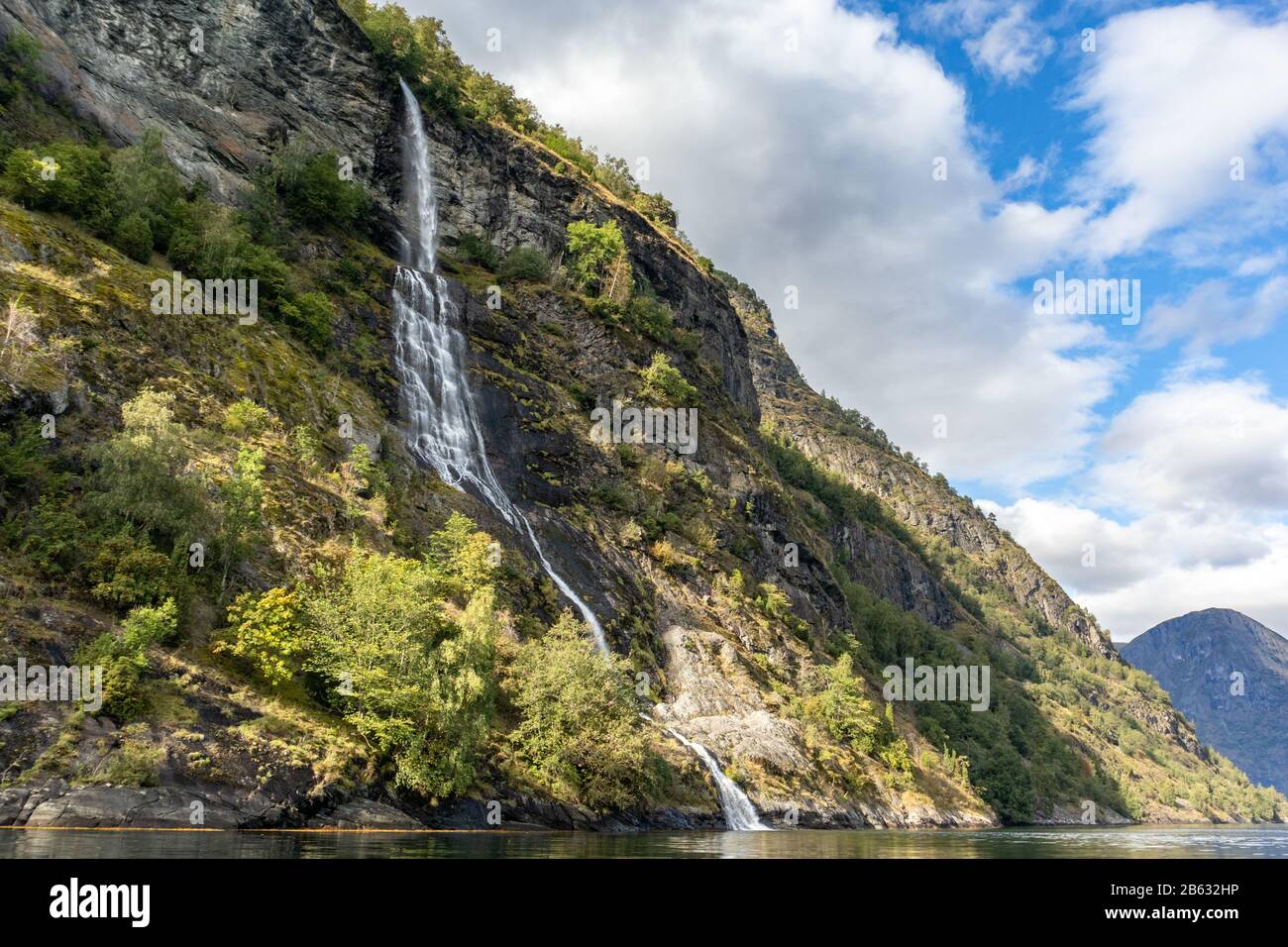 Waterfall falling into norwegian fjord Aurlandsfjord. Close bright ...