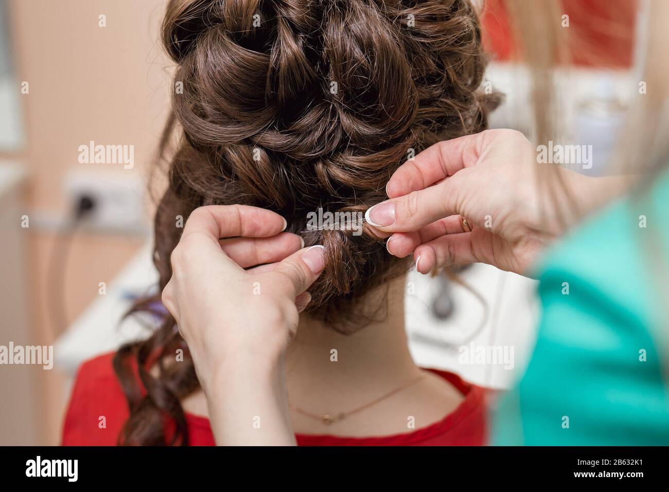 Closeup hairdresser coiffeur makes evening hairstyle Stock Photo - Alamy