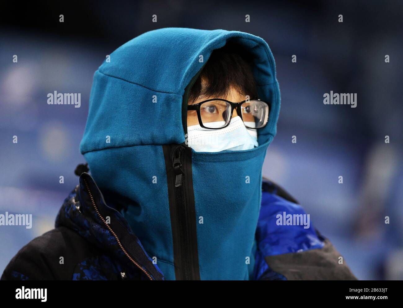 A fan wearing a protective mask in the stands to prevent the spread of ...