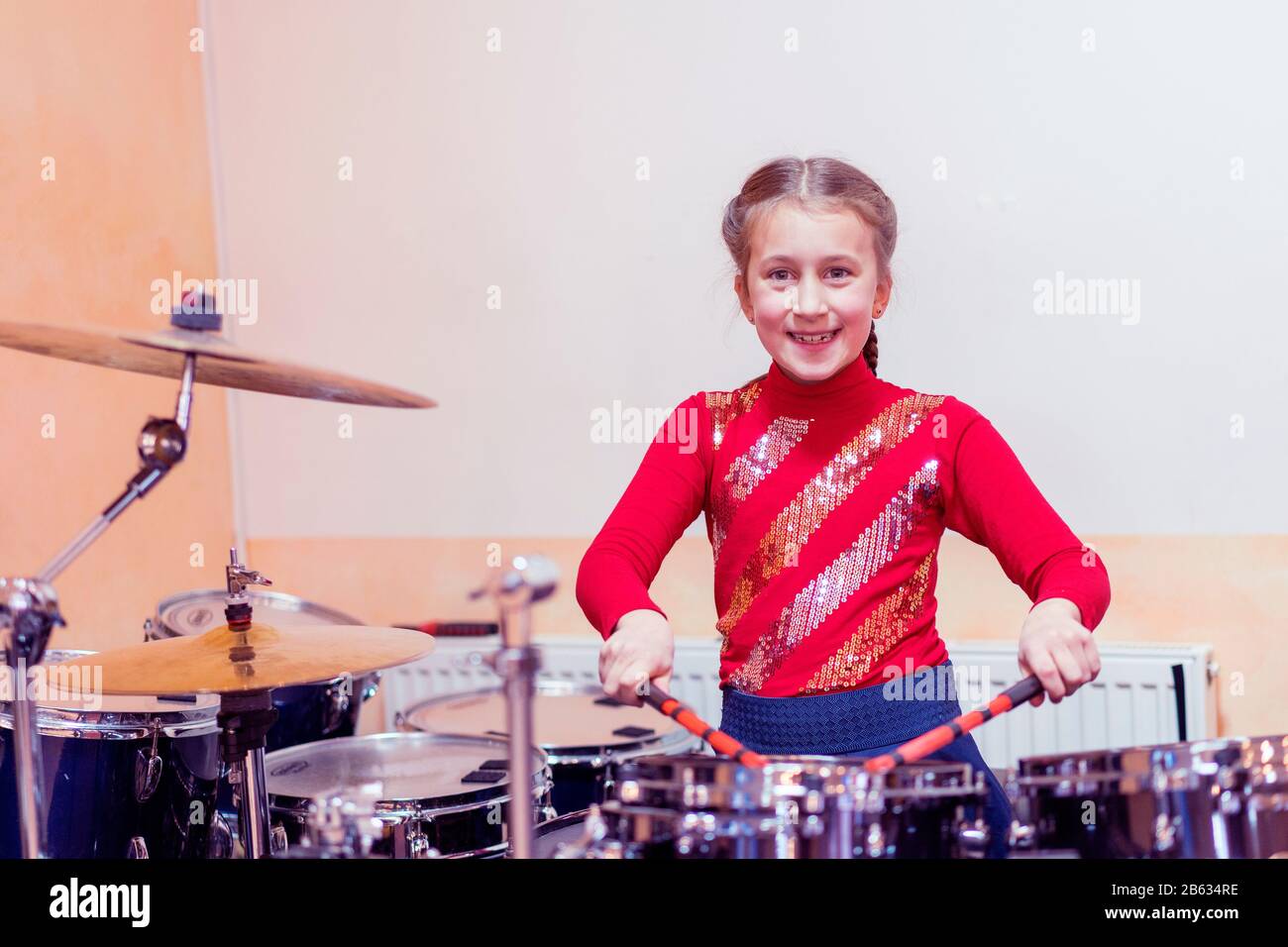 happy girl playing the drums. Teen girls are having fun playing drum ...