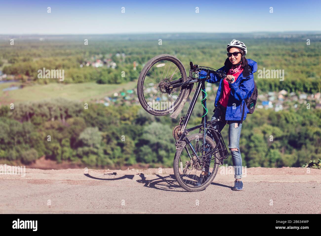 happy young women traveler on bicycle with arms and legs raised ...