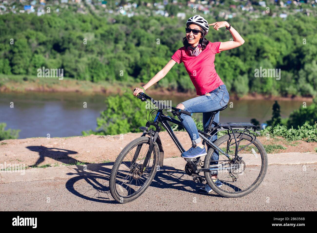 Bike helmet - woman putting biking helmet on outside during bicycle ...