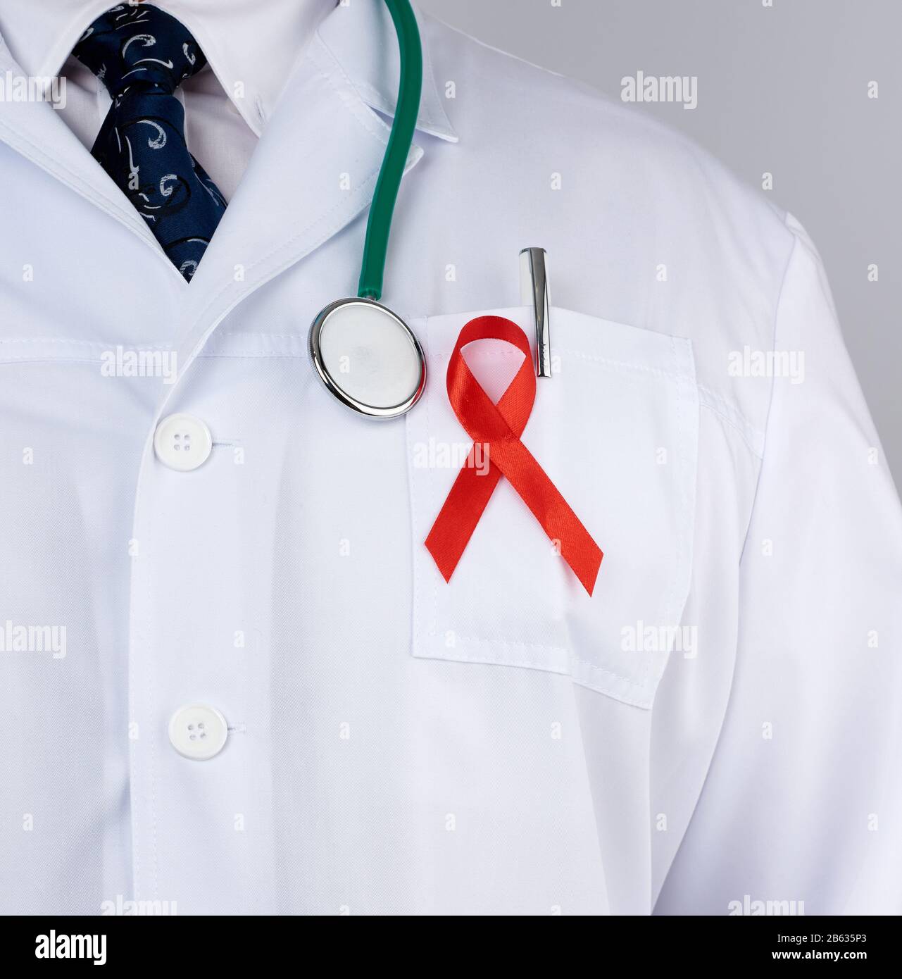 doctor in a white coat and tie is standing on a white background, red ...