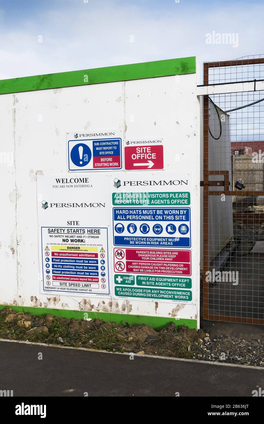 Signs at entrance to a UK building site advising of safety rules and ...