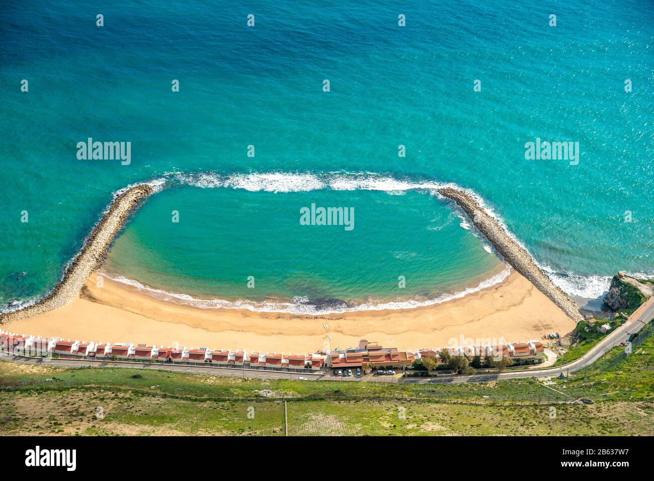 beach on ocean coast with barriers to protect against waves and water ...