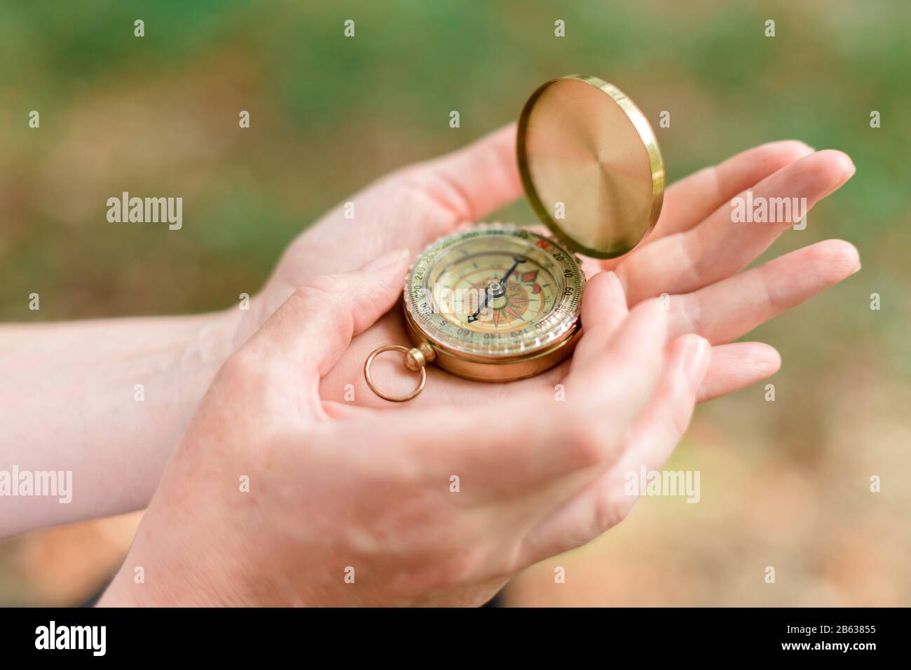 Female hiker using compass for navigation and orientation while ...