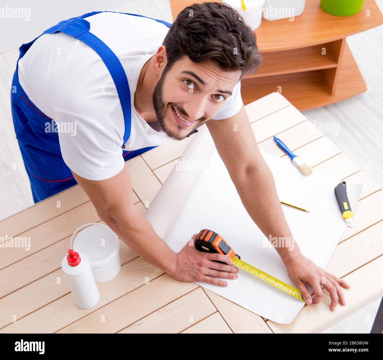 The worker working on wallpaper during refurbishment Stock Photo - Alamy