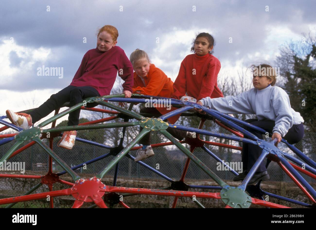 four girls on climbing frame in run down playground Stock Photo - Alamy