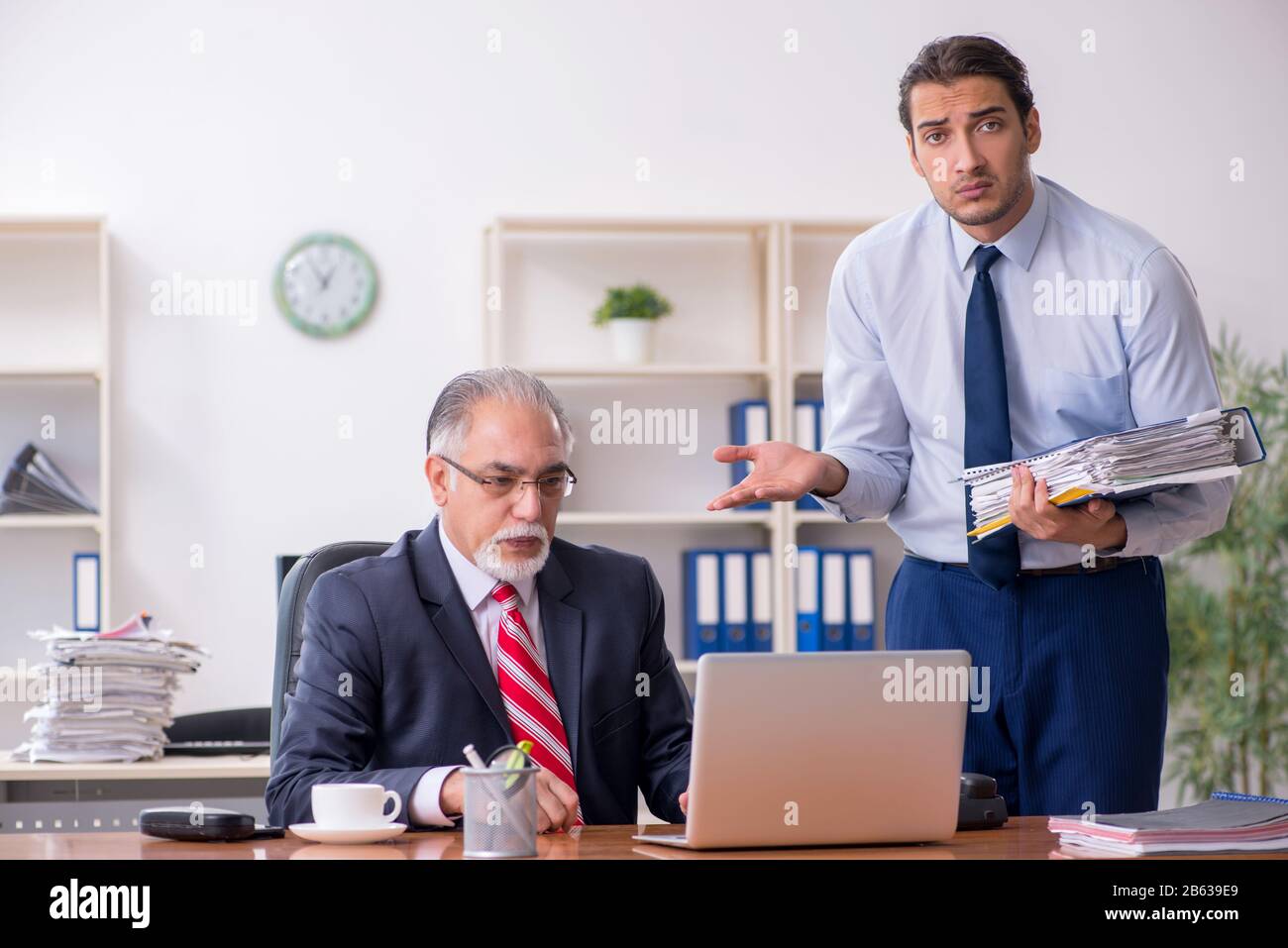 Old boss and young employee in the office Stock Photo - Alamy