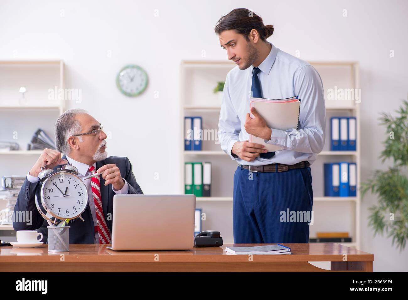 Old boss and young employee in the office Stock Photo - Alamy