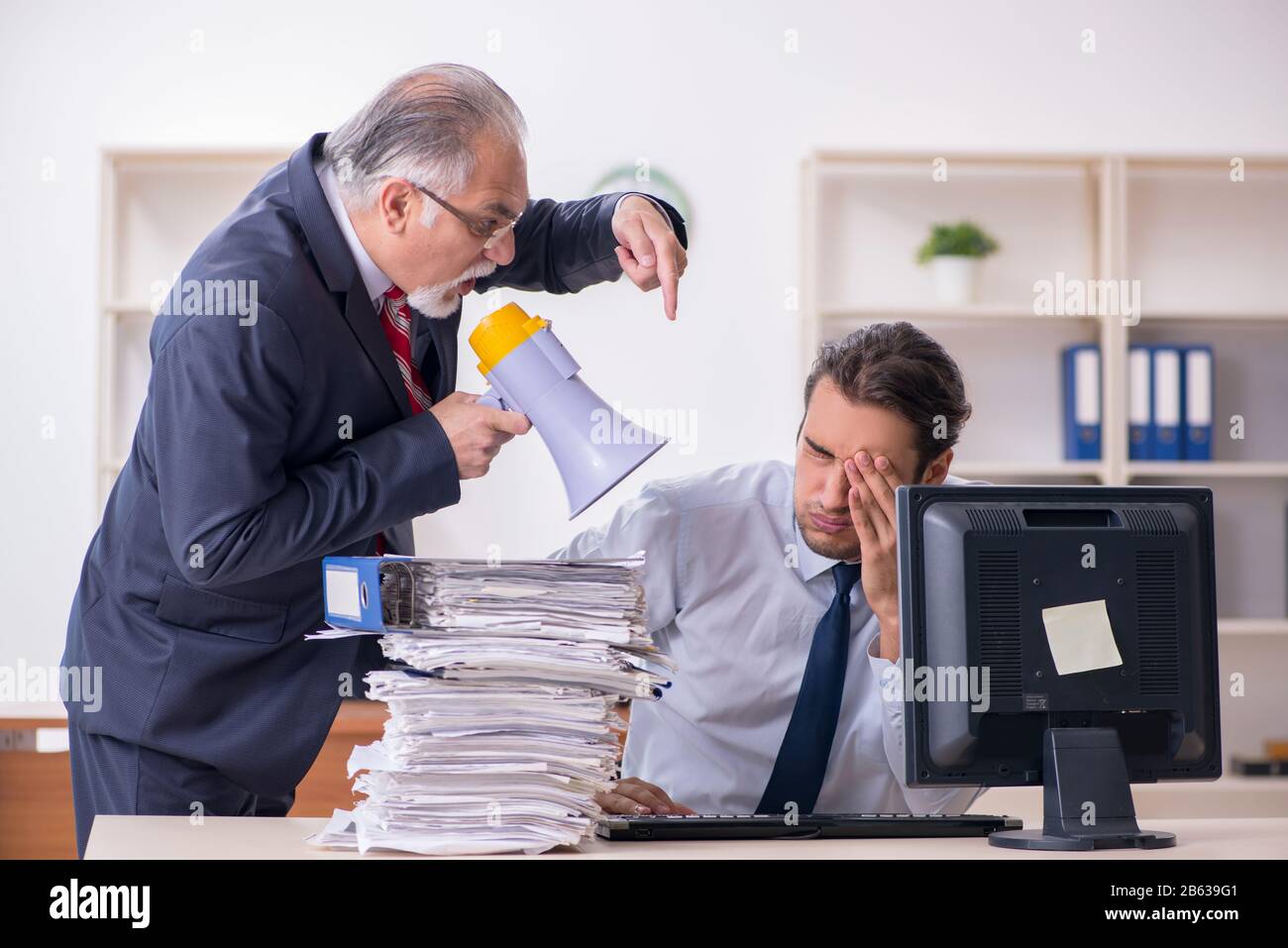 Old boss and young employee in the office Stock Photo - Alamy