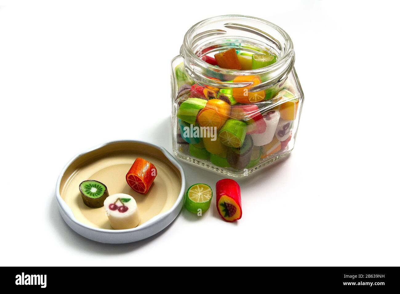Colored candies in an open glass jar isolated on white background Stock ...