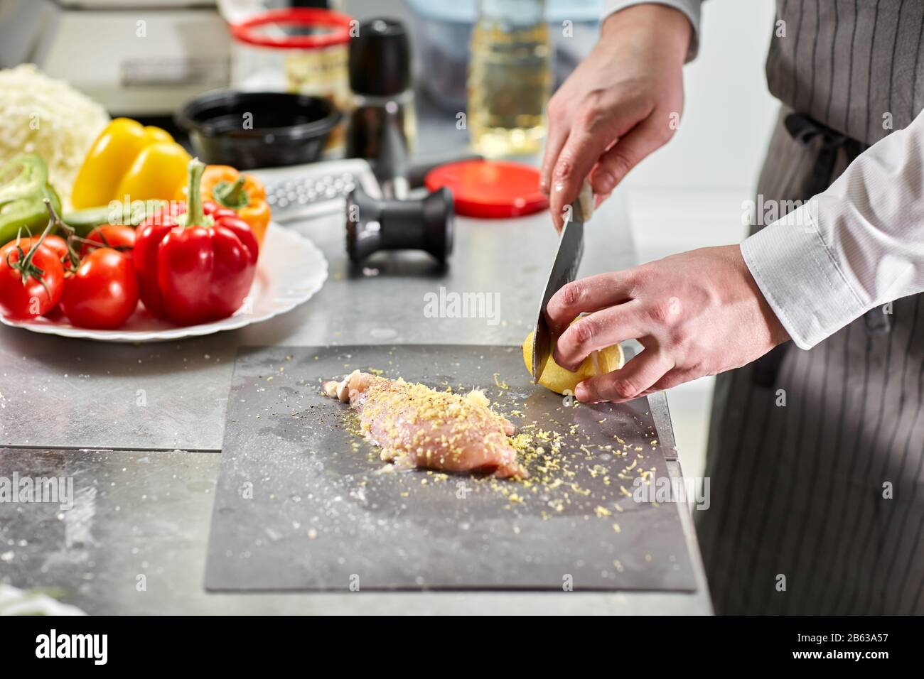 Chief chops and marinates chicken. Professional chef in a kitchen of ...