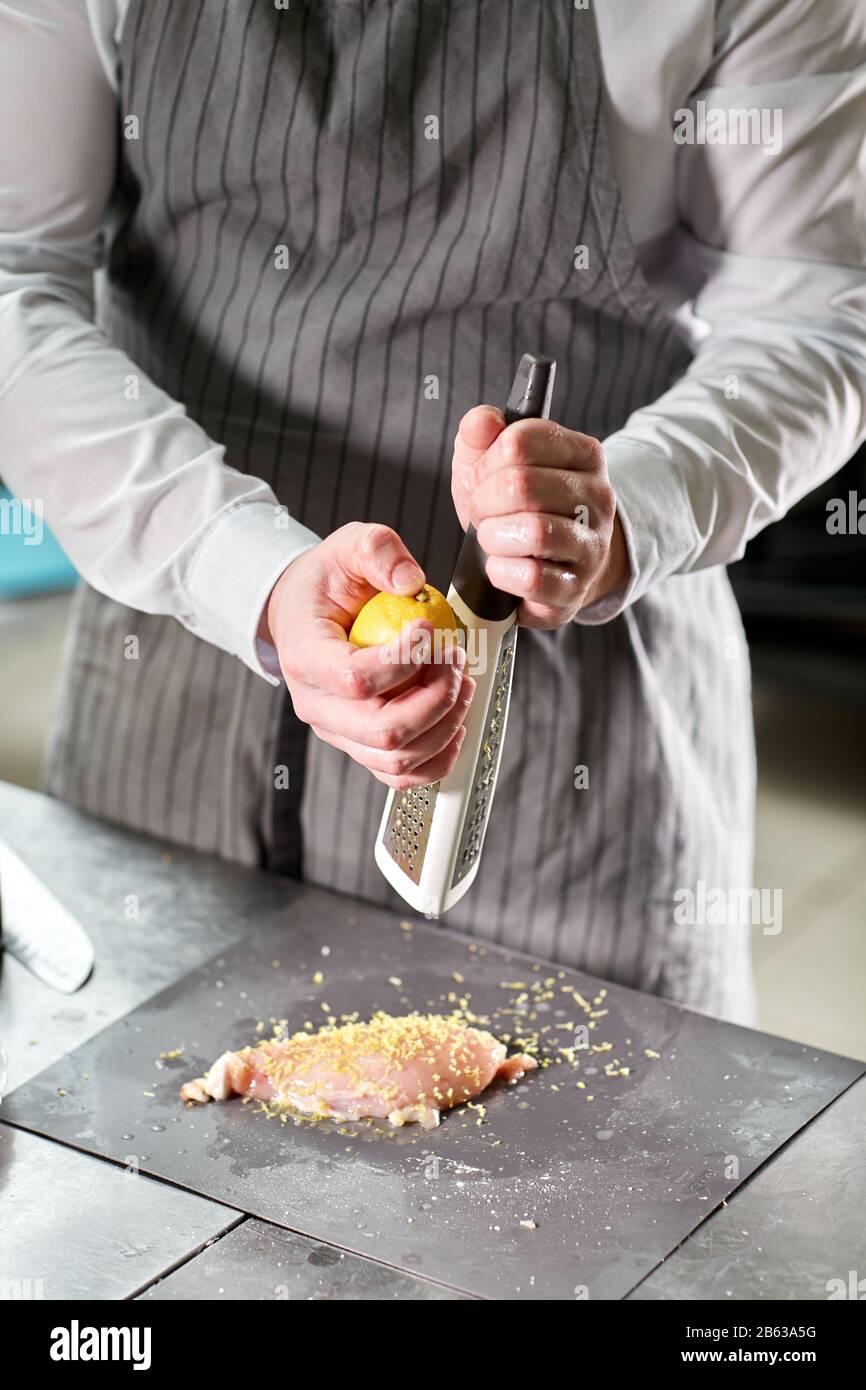 Chief chops and marinates chicken. Professional chef in a kitchen of ...