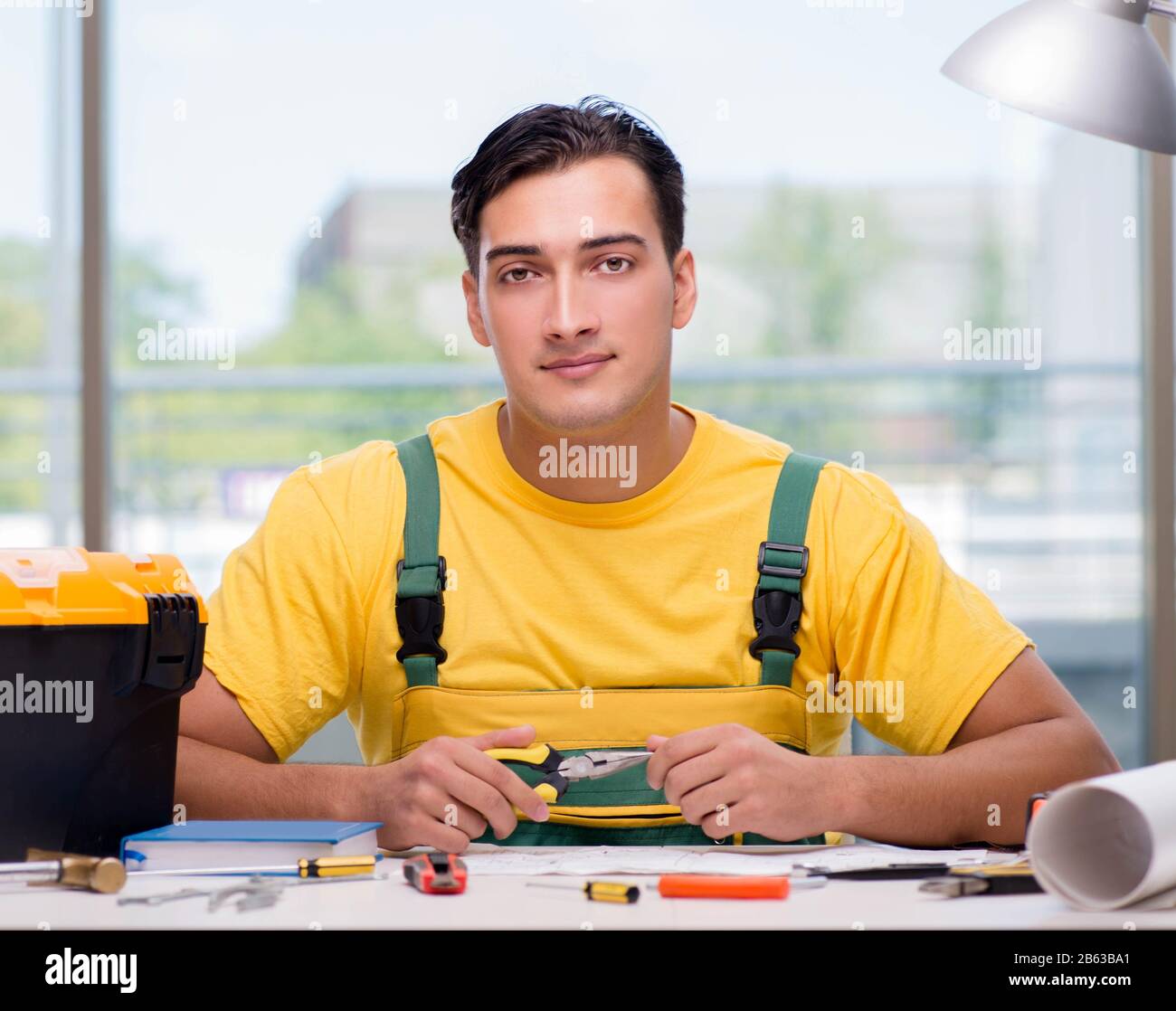 The construction worker sitting at the desk Stock Photo - Alamy