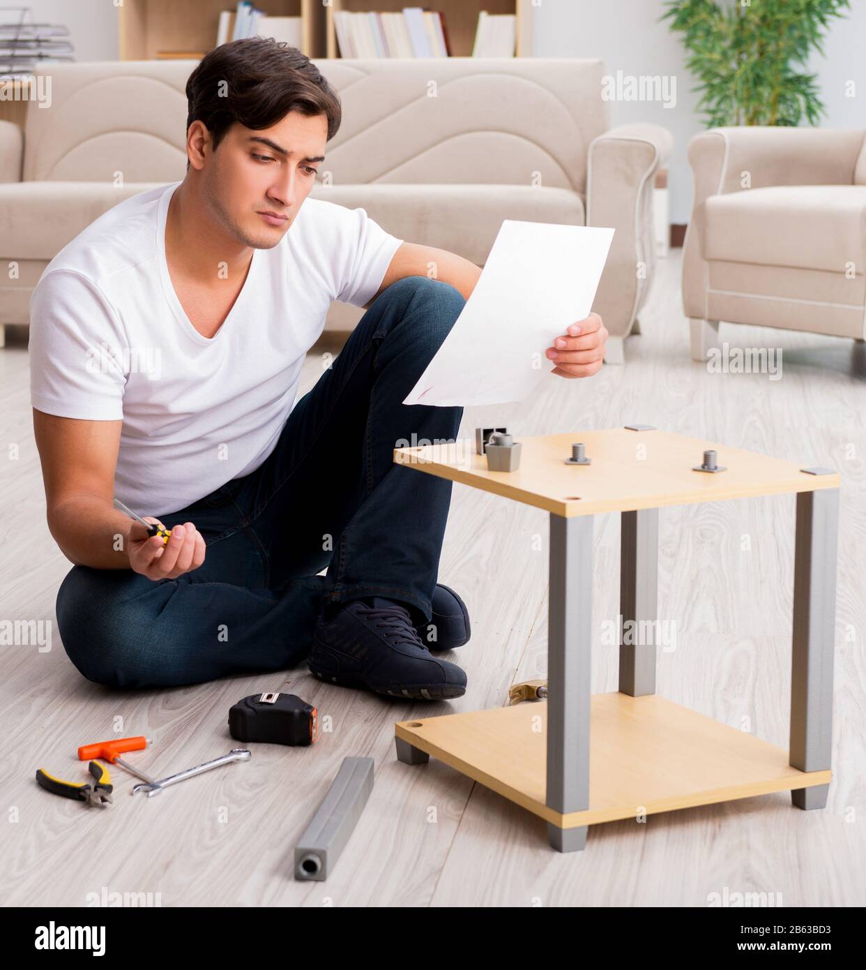 The man assembling shelf at home Stock Photo - Alamy