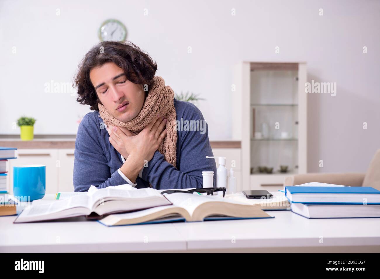 The sick male student suffering at home Stock Photo - Alamy