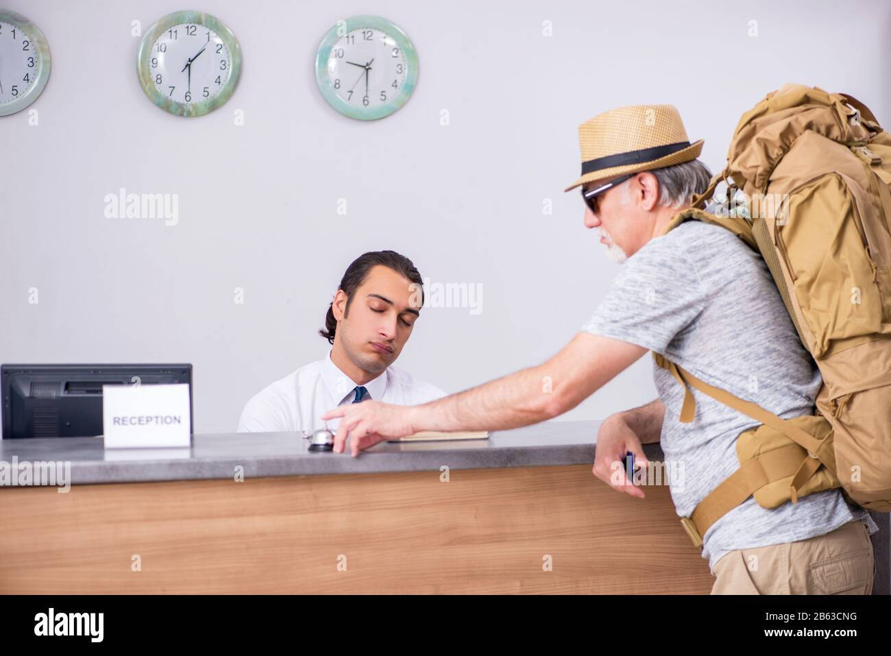 Old backpacker at the hotel reception Stock Photo - Alamy