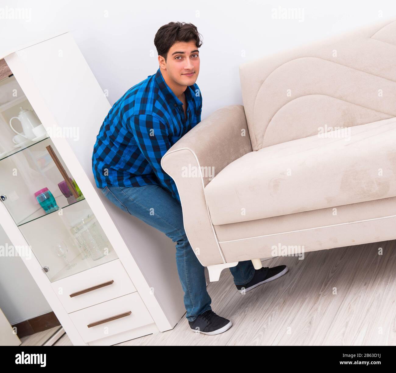 The young man moving sofa couch Stock Photo - Alamy