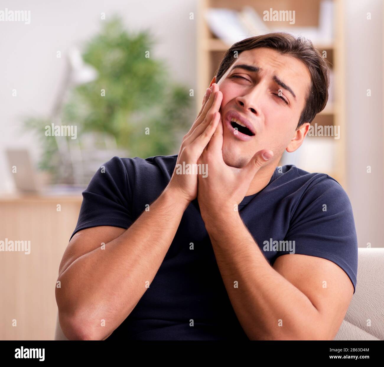 The young handsome man suffering from pain Stock Photo - Alamy
