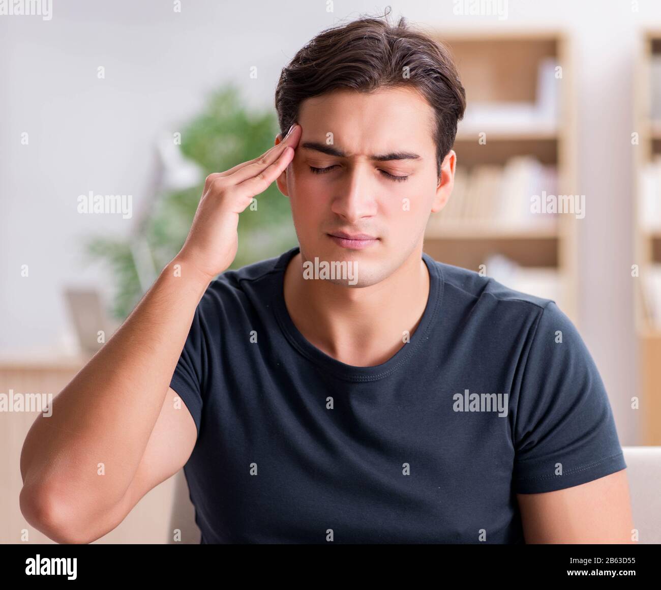 The young handsome man suffering from pain Stock Photo - Alamy
