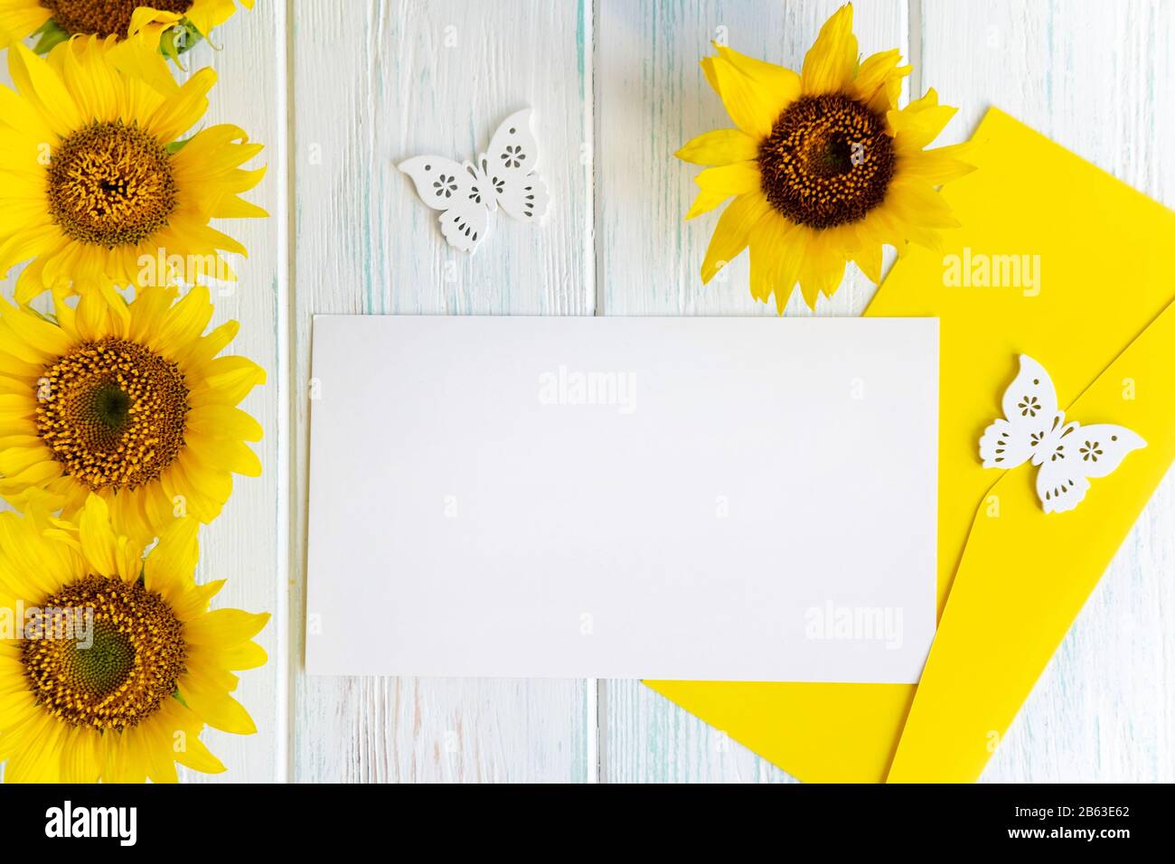 Mock up template with sunflower flowers and an envelope for writing ...
