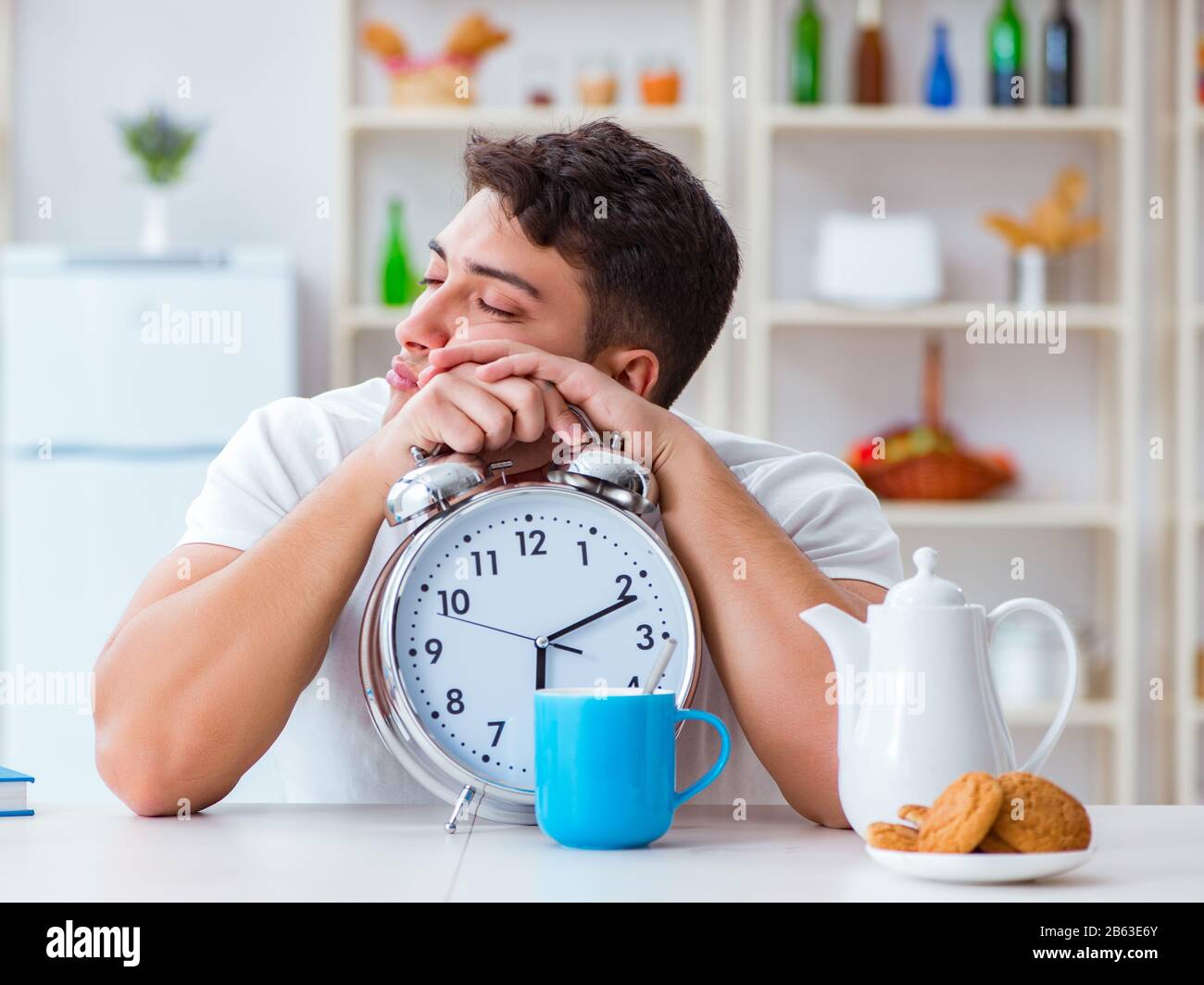 The man with alarm clock falling asleep at breakfast Stock Photo - Alamy