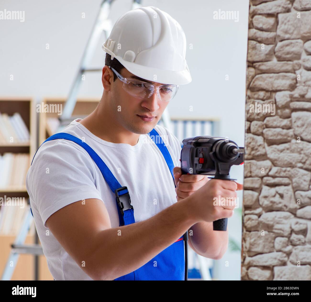 The repairman working with drilling drill perforator Stock Photo - Alamy