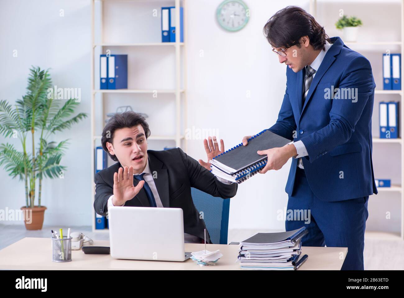 The boss and his male assistant working in the office Stock Photo - Alamy