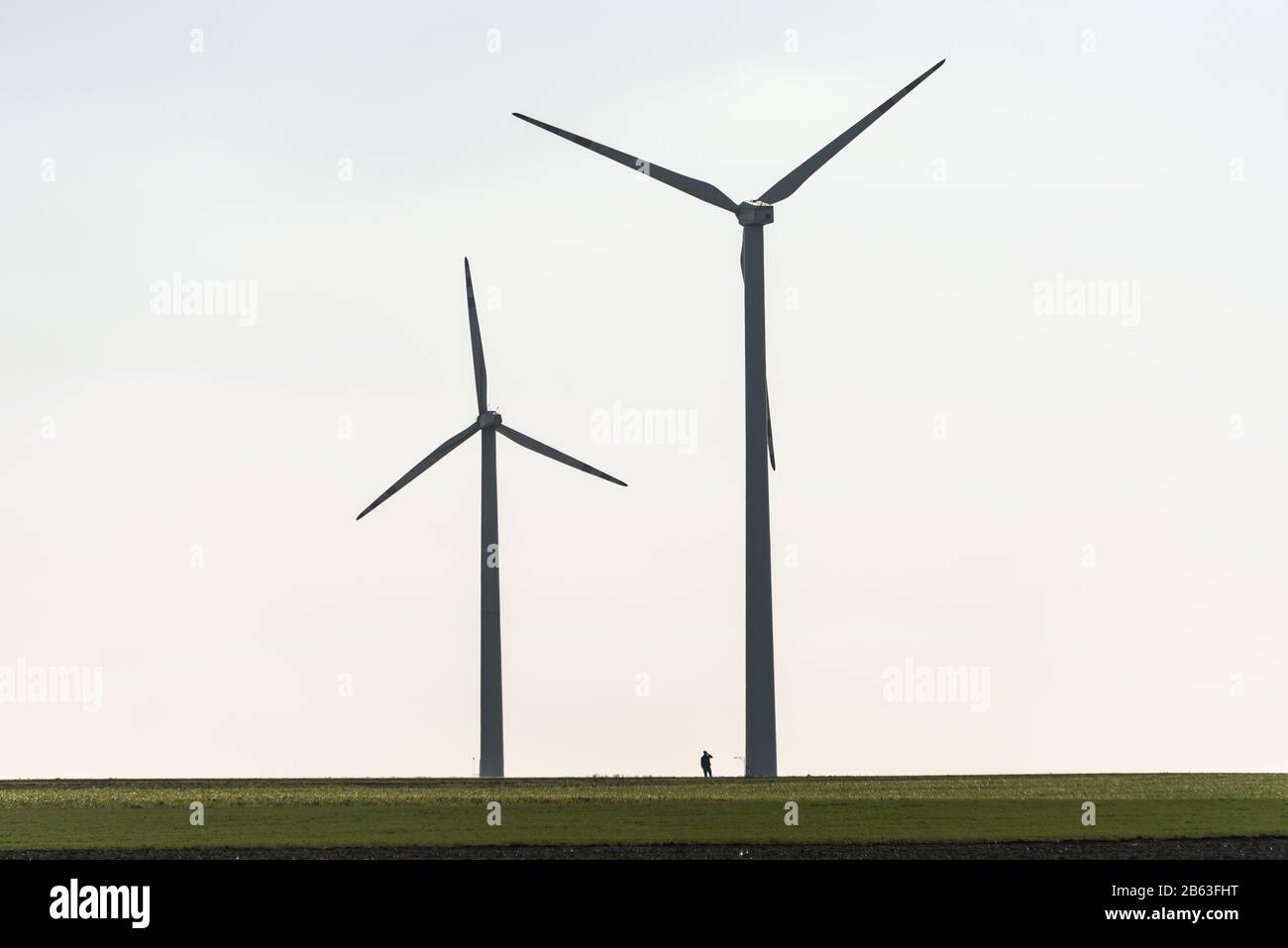 Two wind farms and a human silhouette showing the scale of windmill and ...
