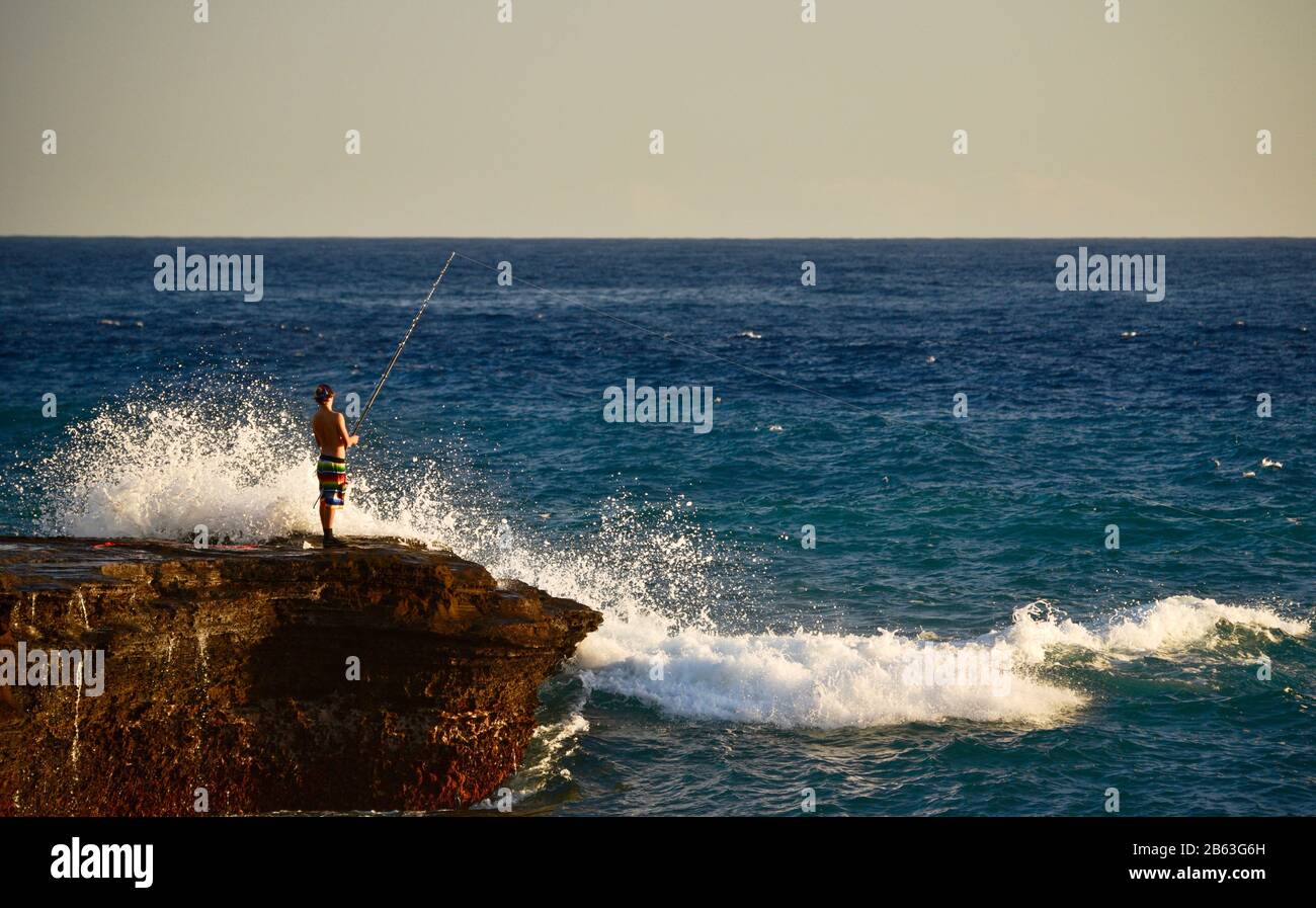 Fisherman manning fishing pole on cliff and ledges during sunset at ...