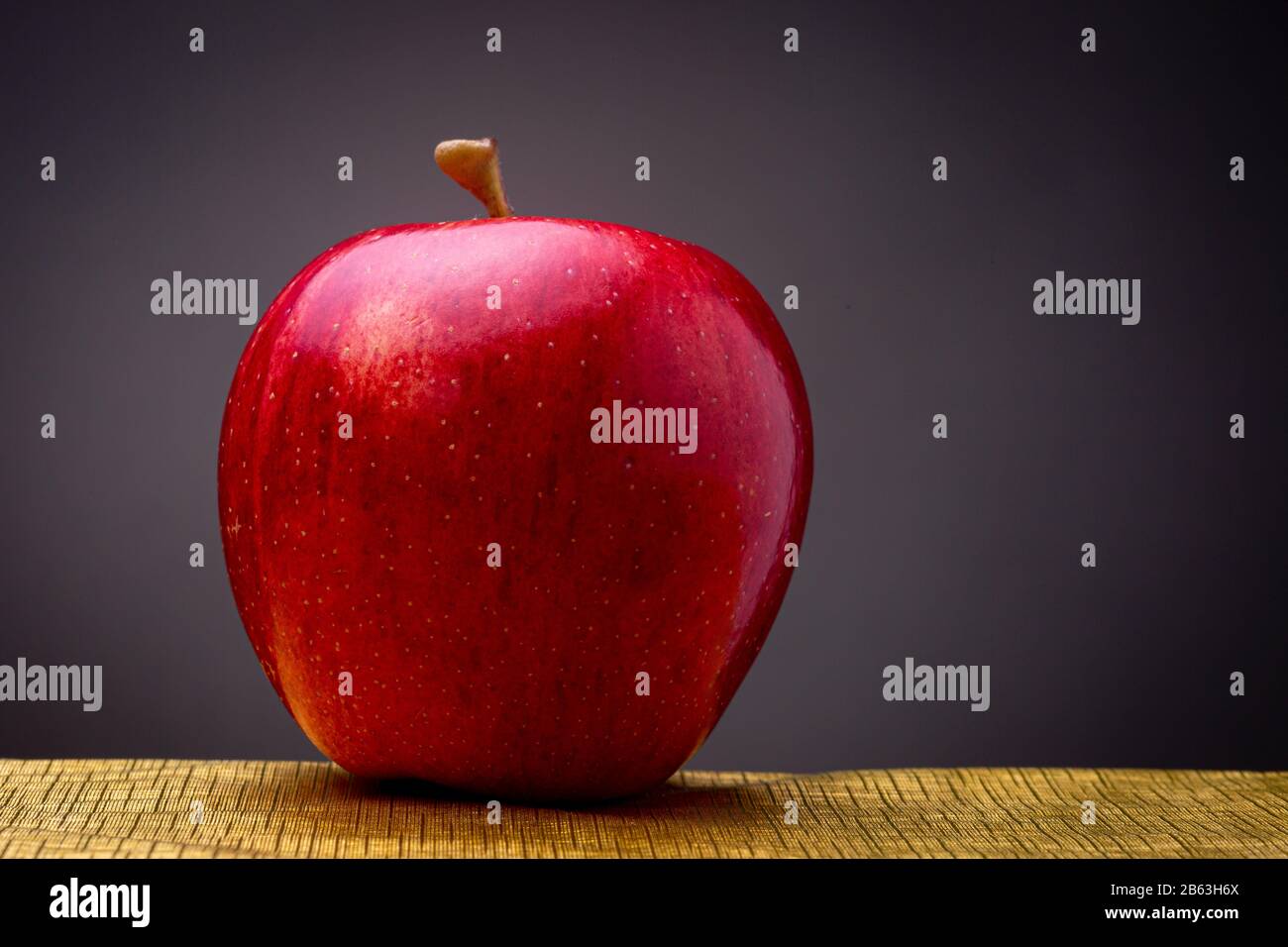 Vibrant bright red apple against dark studio background Stock Photo - Alamy