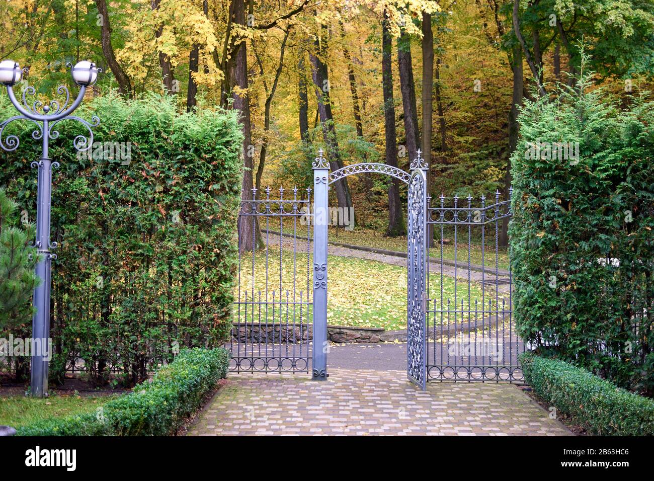 Opened city park gate that leads into a garden Stock Photo - Alamy