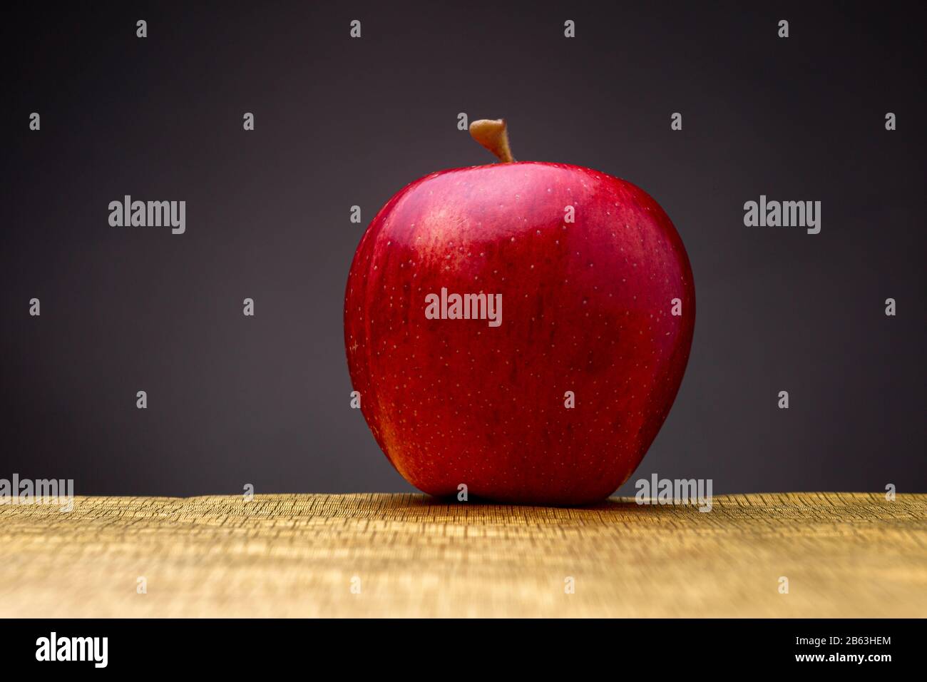 Vibrant bright red apple against dark studio background Stock Photo - Alamy