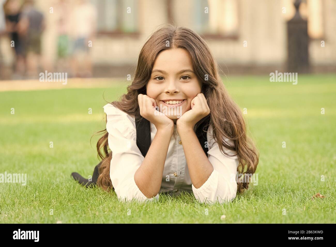 Dreaming of future. Happy girl relax on green grass. Small child with ...