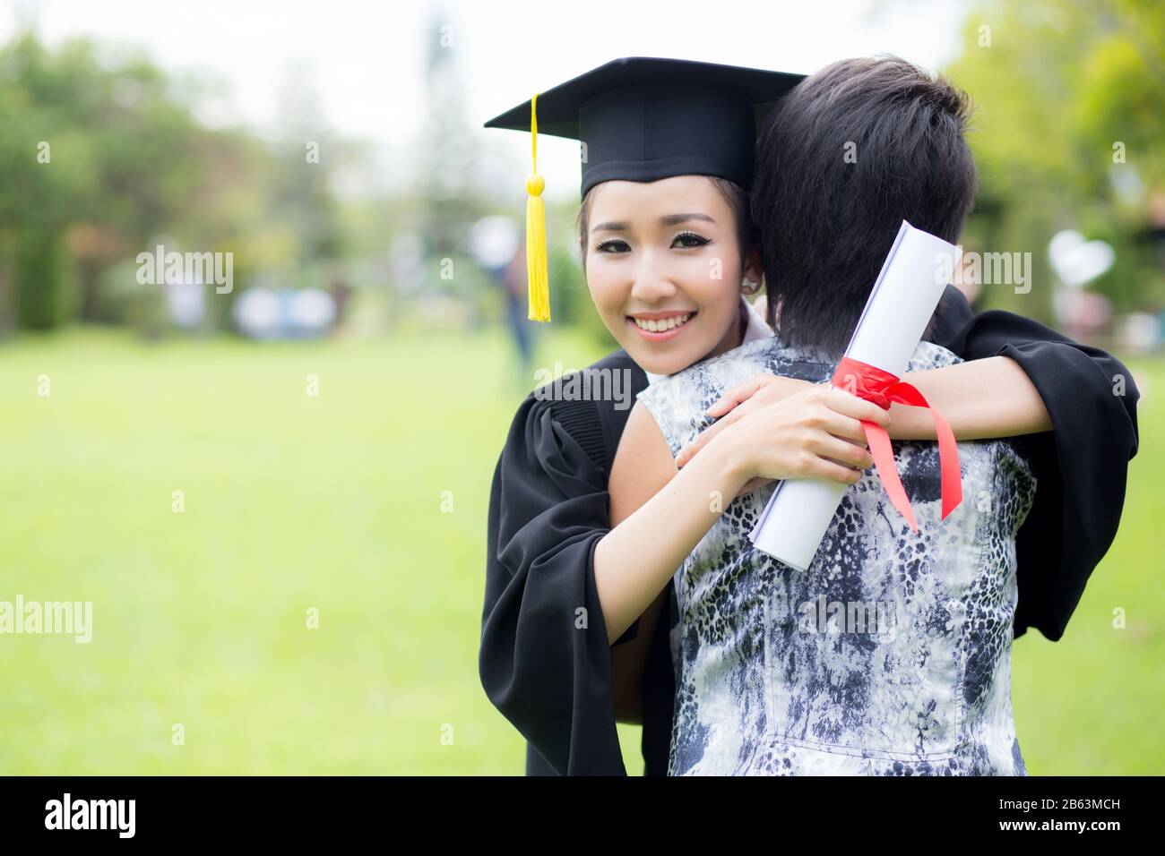 young female graduate hugging her friend at graduation ceremony Stock ...