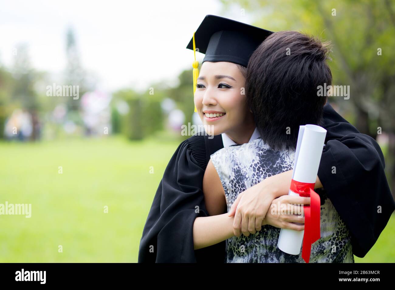 young female graduate hugging her friend at graduation ceremony Stock ...