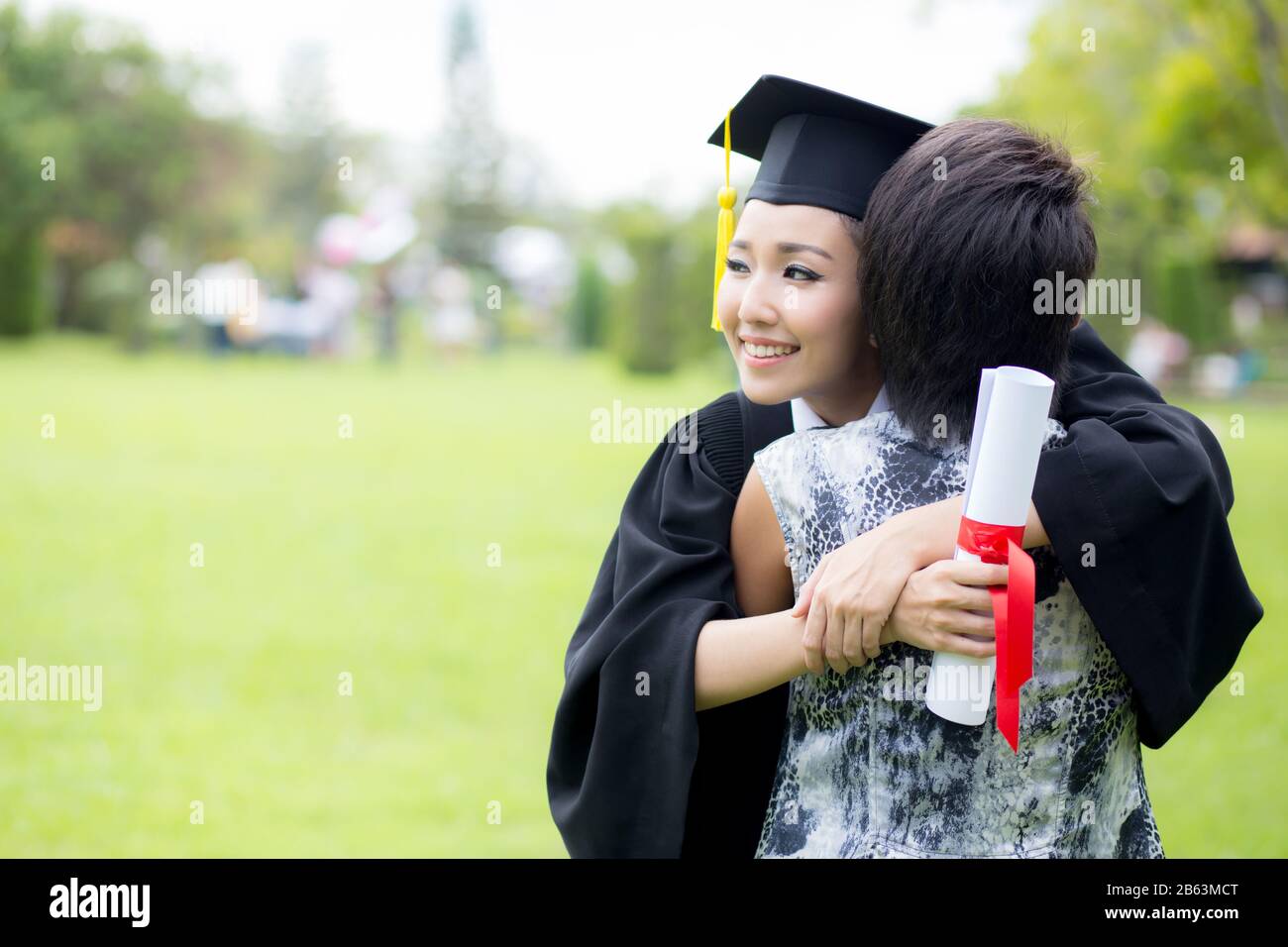 young female graduate hugging her friend at graduation ceremony Stock ...