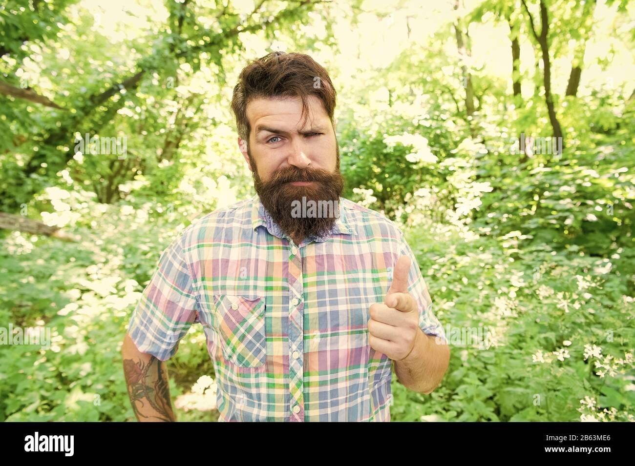 Hey, look. Bearded man pointing finger before him on natural landscape ...