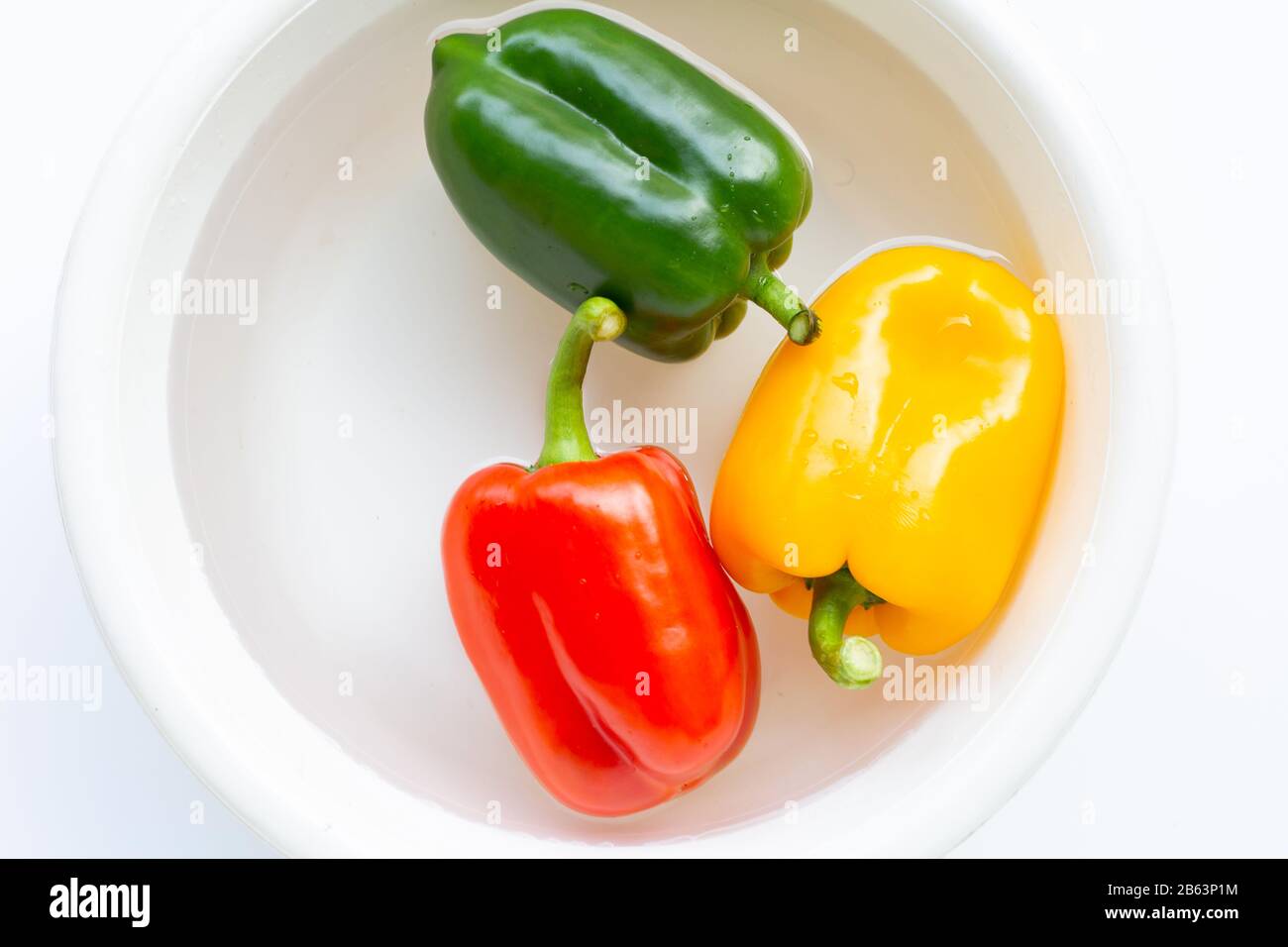 Bell pepper soaked in water. Washing fresh vegetables on white ...