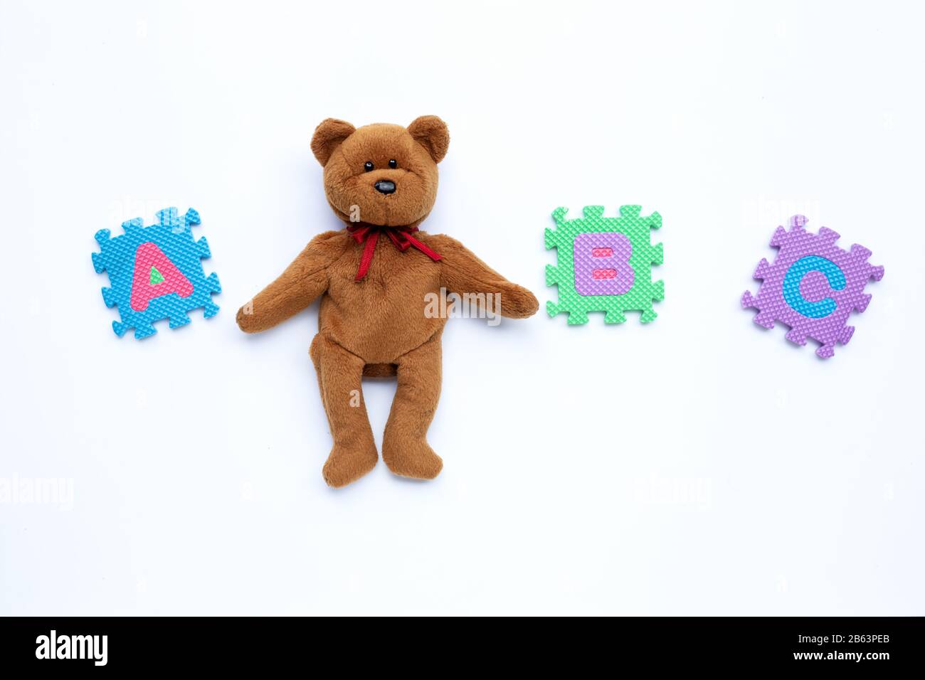 Brown bear toy with english alphabet puzzle on white background ...