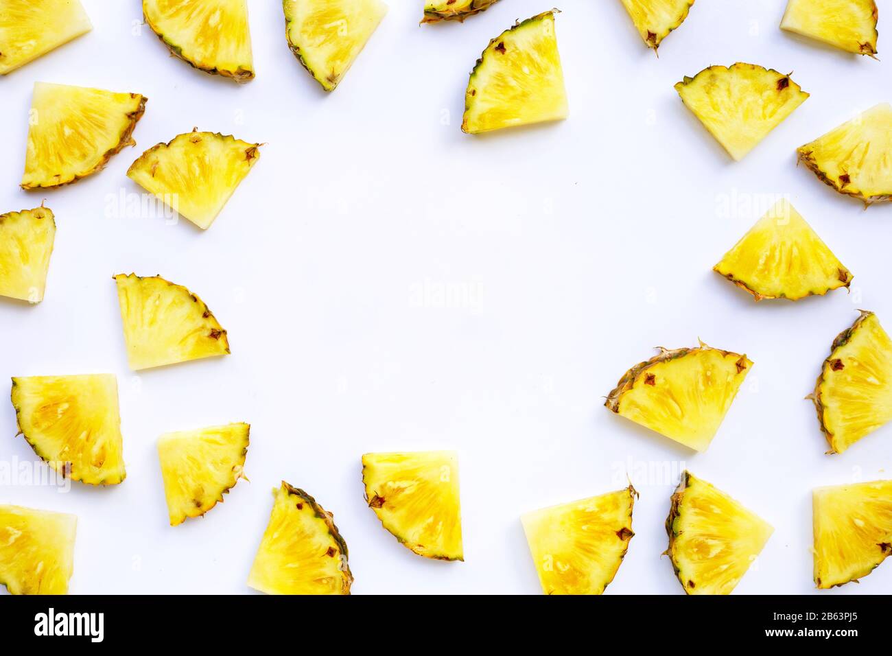 Frame made of fresh pineapple slices on white background. Copy space ...