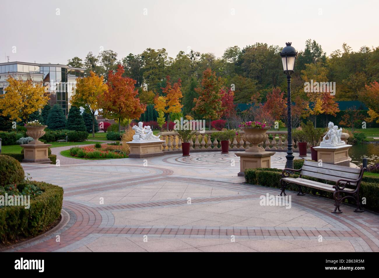 Well-groomed empty park with benches, trees and cobblestone foor Stock ...