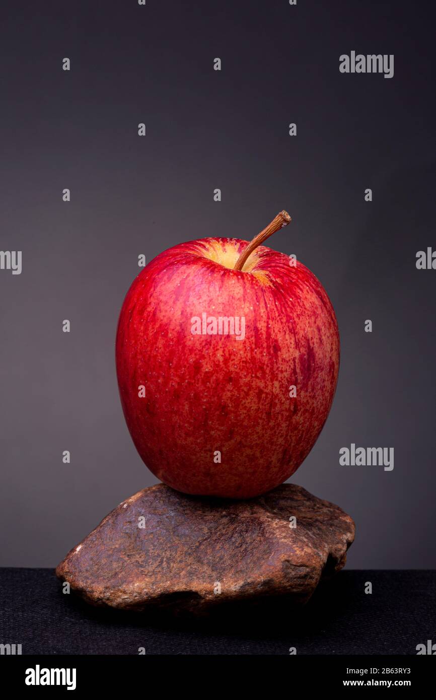 Vibrant bright red apple against dark studio background Stock Photo - Alamy