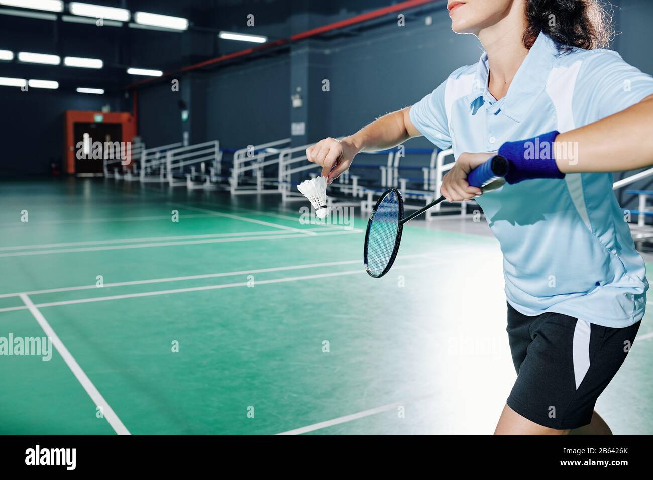 Cropped image of sportswoman serving shuttlecock when playing badminton ...