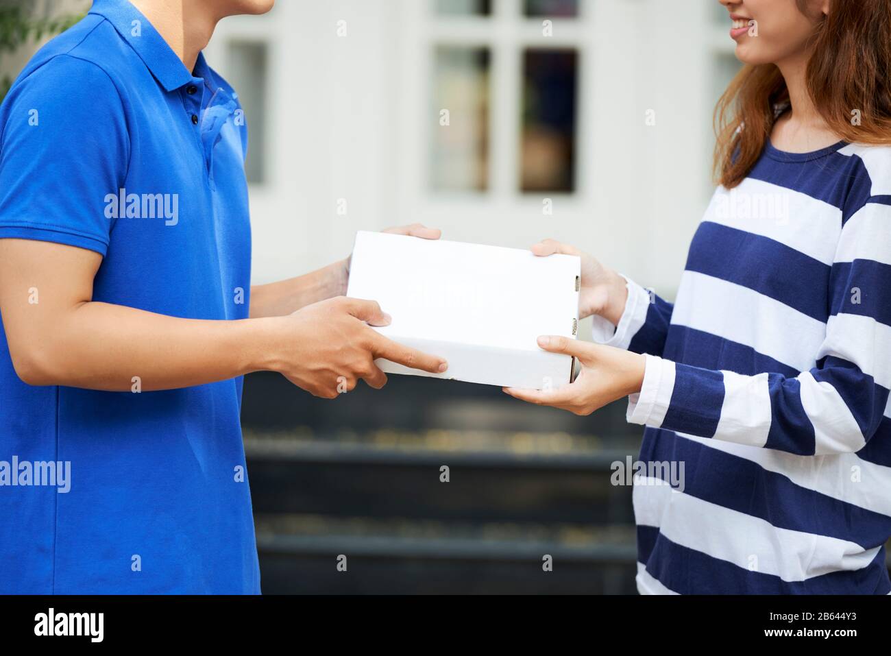Close-up image of delivery man giving box to female customer Stock ...