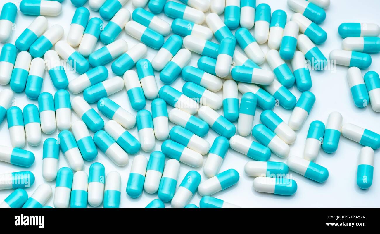 Blue and white capsule pills on white background. Pharmaceutical ...