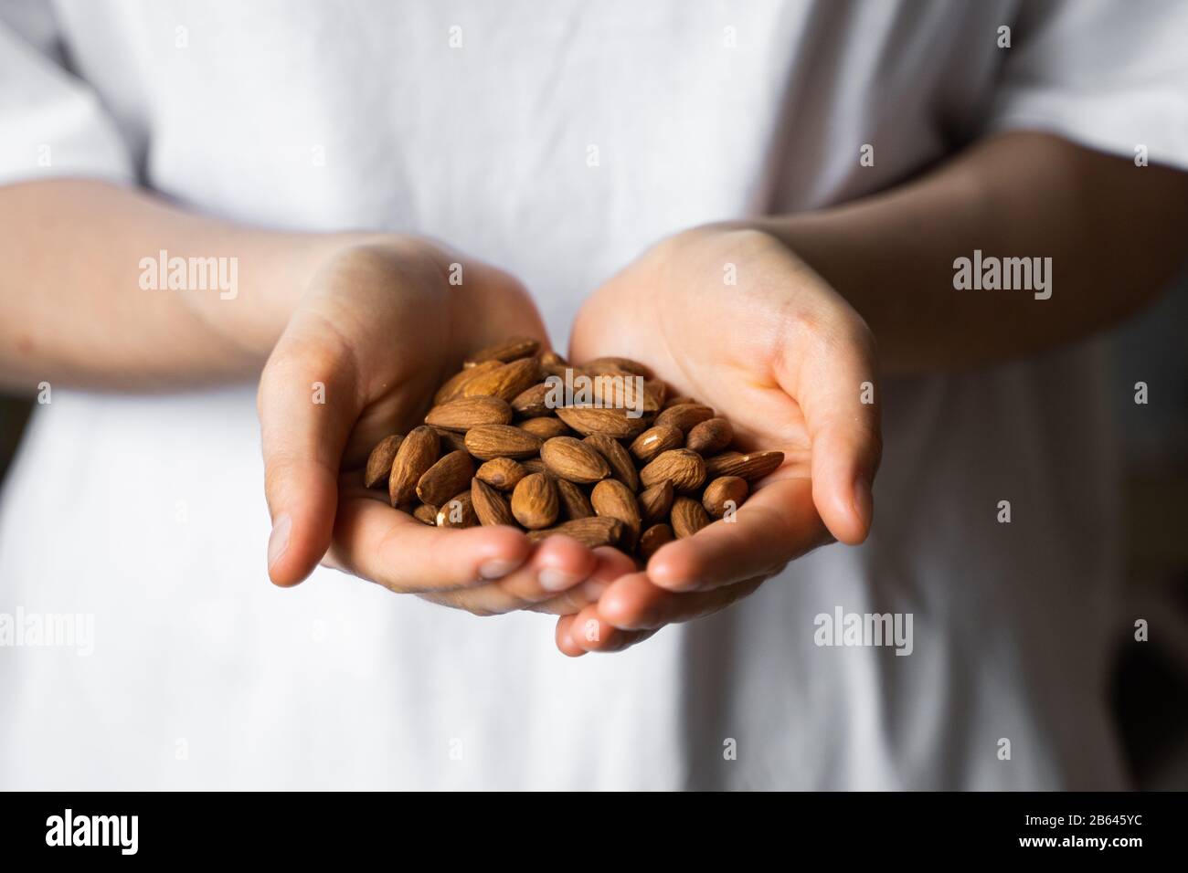Almond in a womans hands. Almonds nuts is a healthy vegetarian protein ...