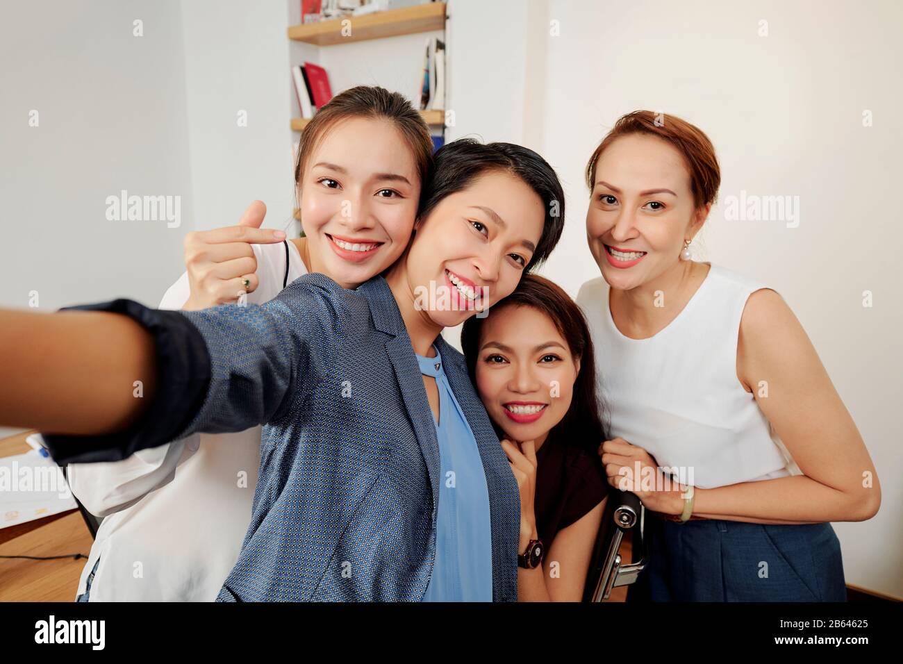 Successful team of smiling Vietnamese businesswomen posing for group ...