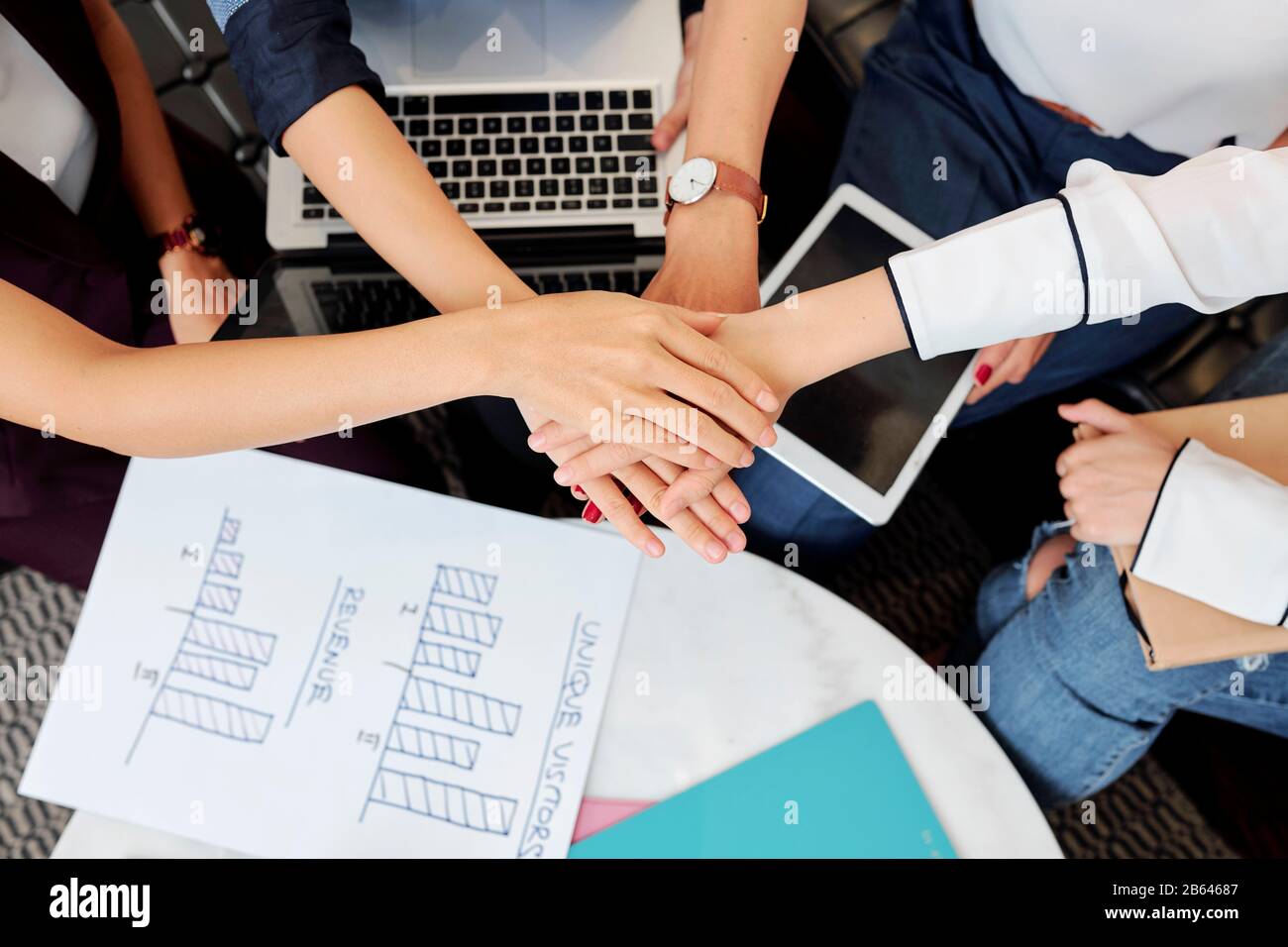 Group of businesswomen stacking hands over the table and celebrating ...